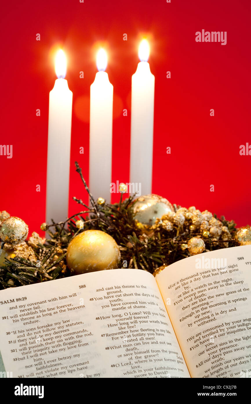 An open Bible with candle and flowers Stock Photo - Alamy