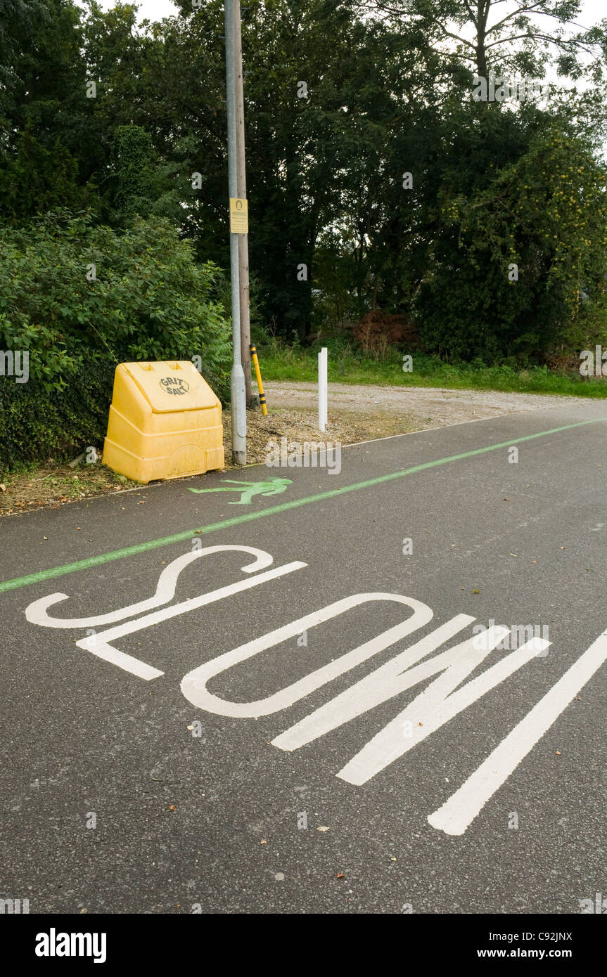 Slow traffic warning sign and roadside grit and salt container in ...
