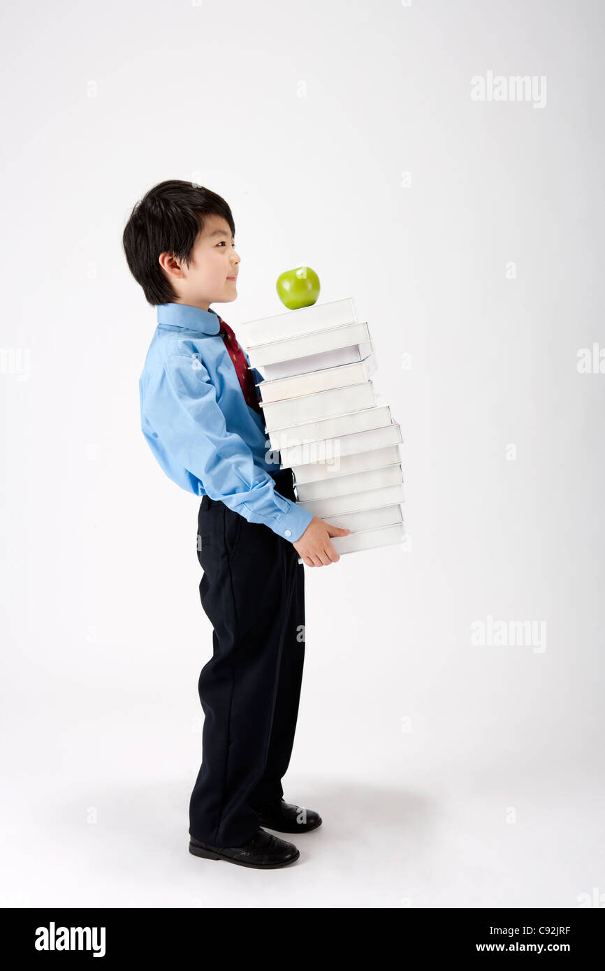 A boy carrying stack of books, side view Stock Photo - Alamy