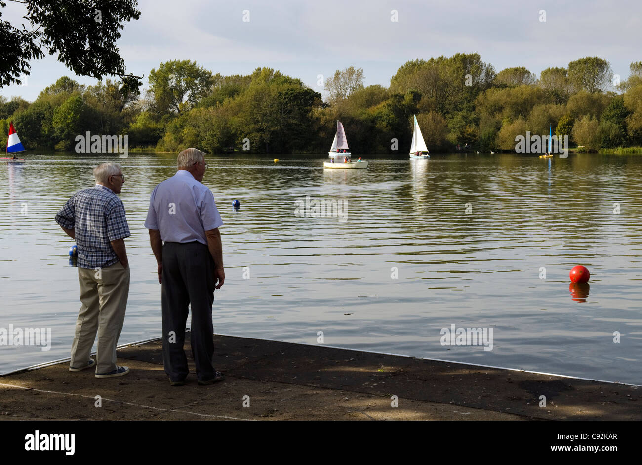 Two old men watching sailing boats on Bury Lake Rickmansworth Aquadrome ...