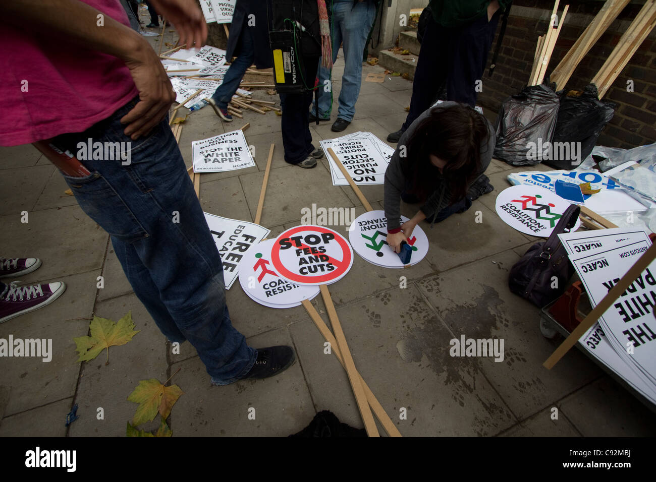 A protester makes placards as students march through central London, UK ...