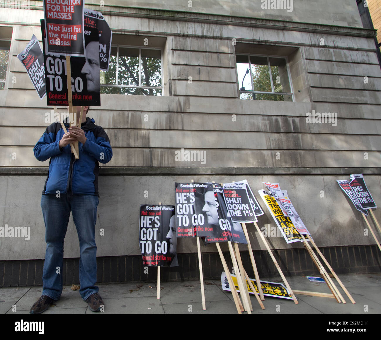 A protester holds placards as students march through central London, UK ...