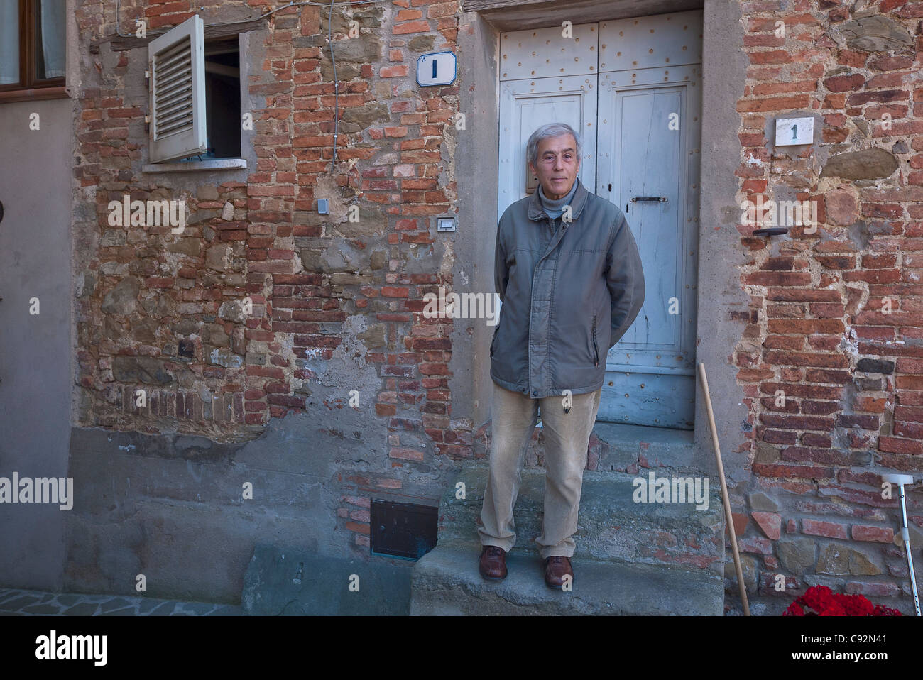 A middle aged Italian man stands on the front step of his home in ...