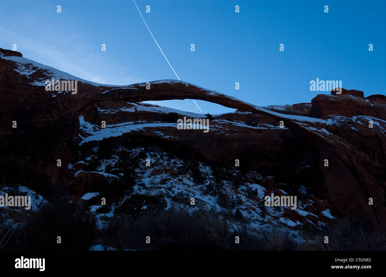 Plane and contrail on Landscape Arch, Arches National Park, Utah, USA ...