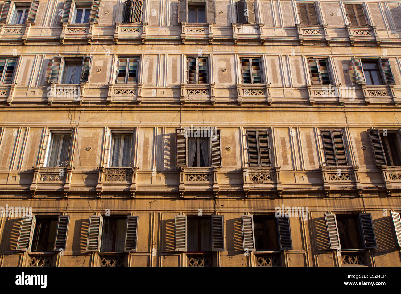 Shuttered facade of a tenement building with wrought iron balconies ...