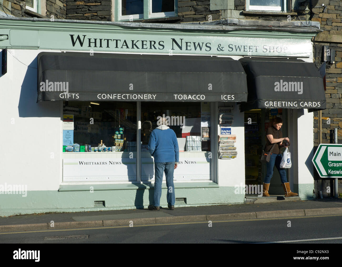 Two people outside newsagent's shop in Ambleside, Lake District ...