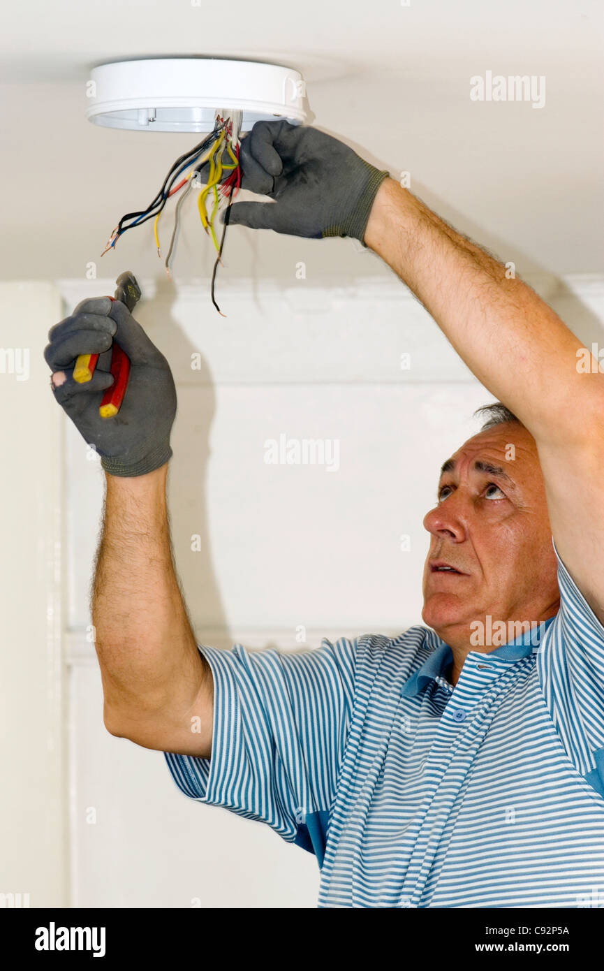 electrician working on a security lighting system in a house Stock ...