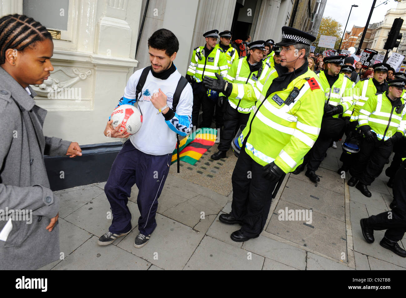 A protester playing football is reprimanded by a police officer during ...