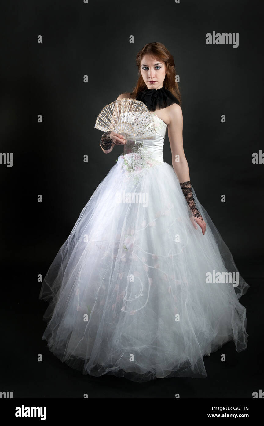 Girl with fan in white dress on black background Stock Photo - Alamy