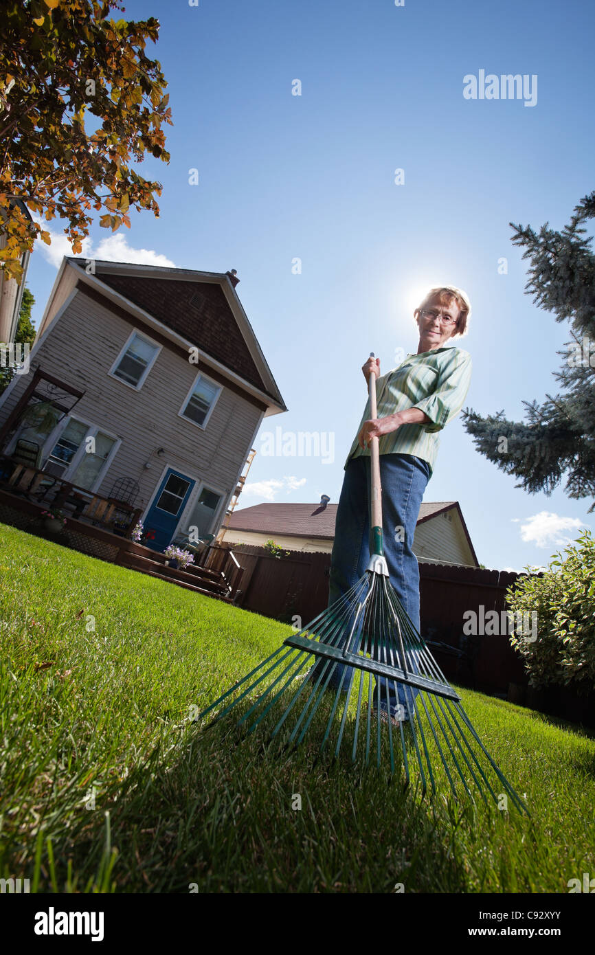 Senior woman standing rake hi-res stock photography and images - Alamy