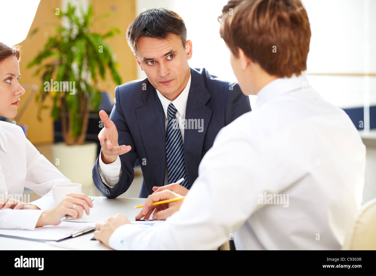 Serious boss giving some information to young office workers Stock ...