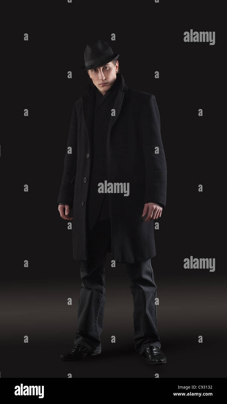Man in black cloth stand - studio shot Stock Photo - Alamy
