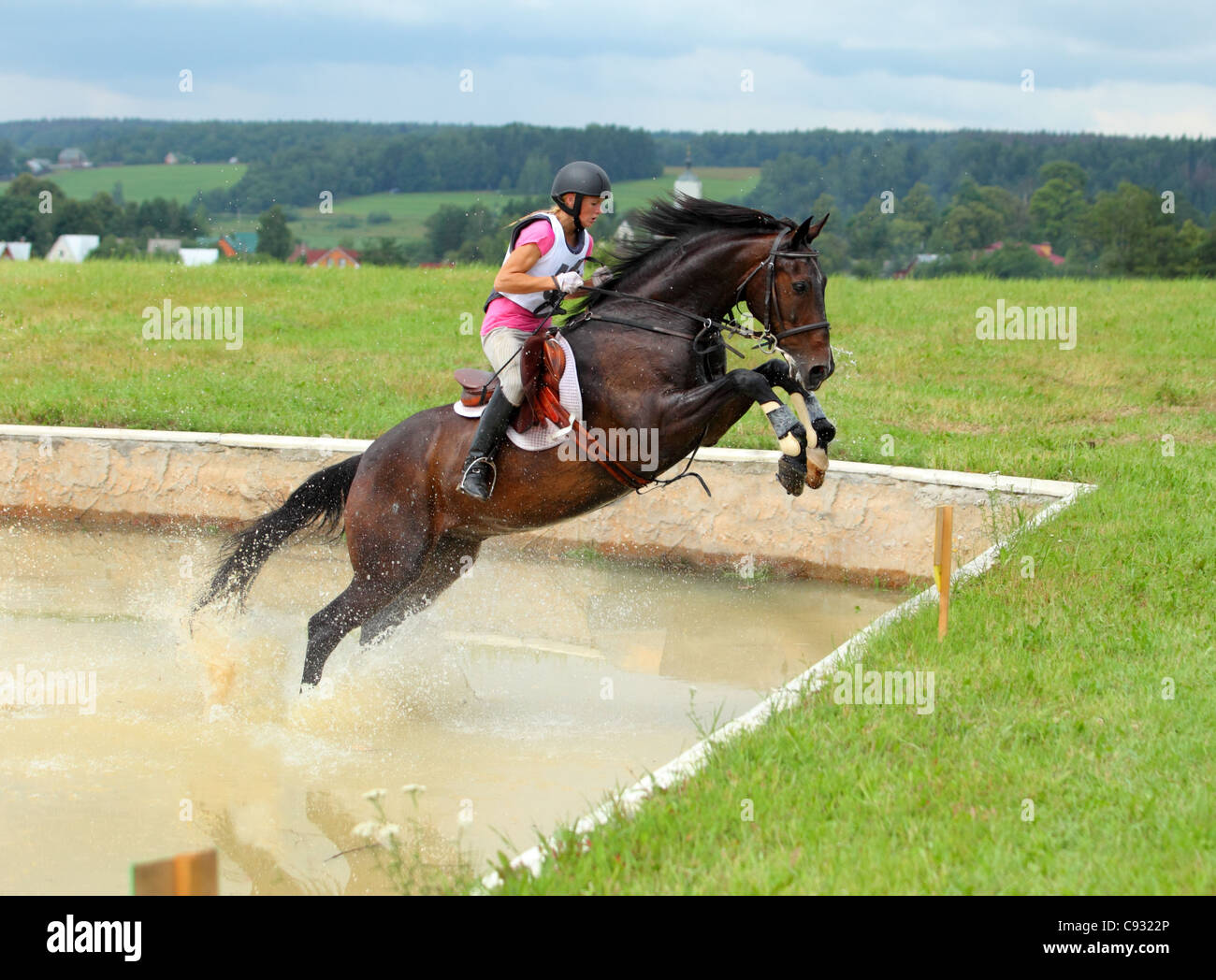 Horse rider jumps a water during a three day eventing Stock Photo - Alamy