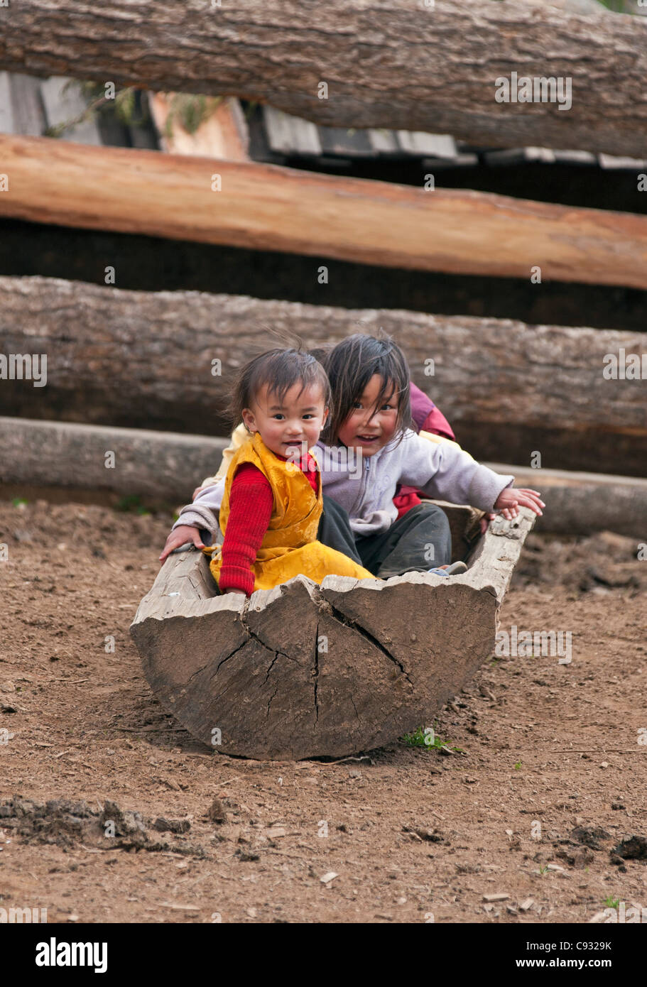 Young children play in an animal feed trough on their parents farm in ...