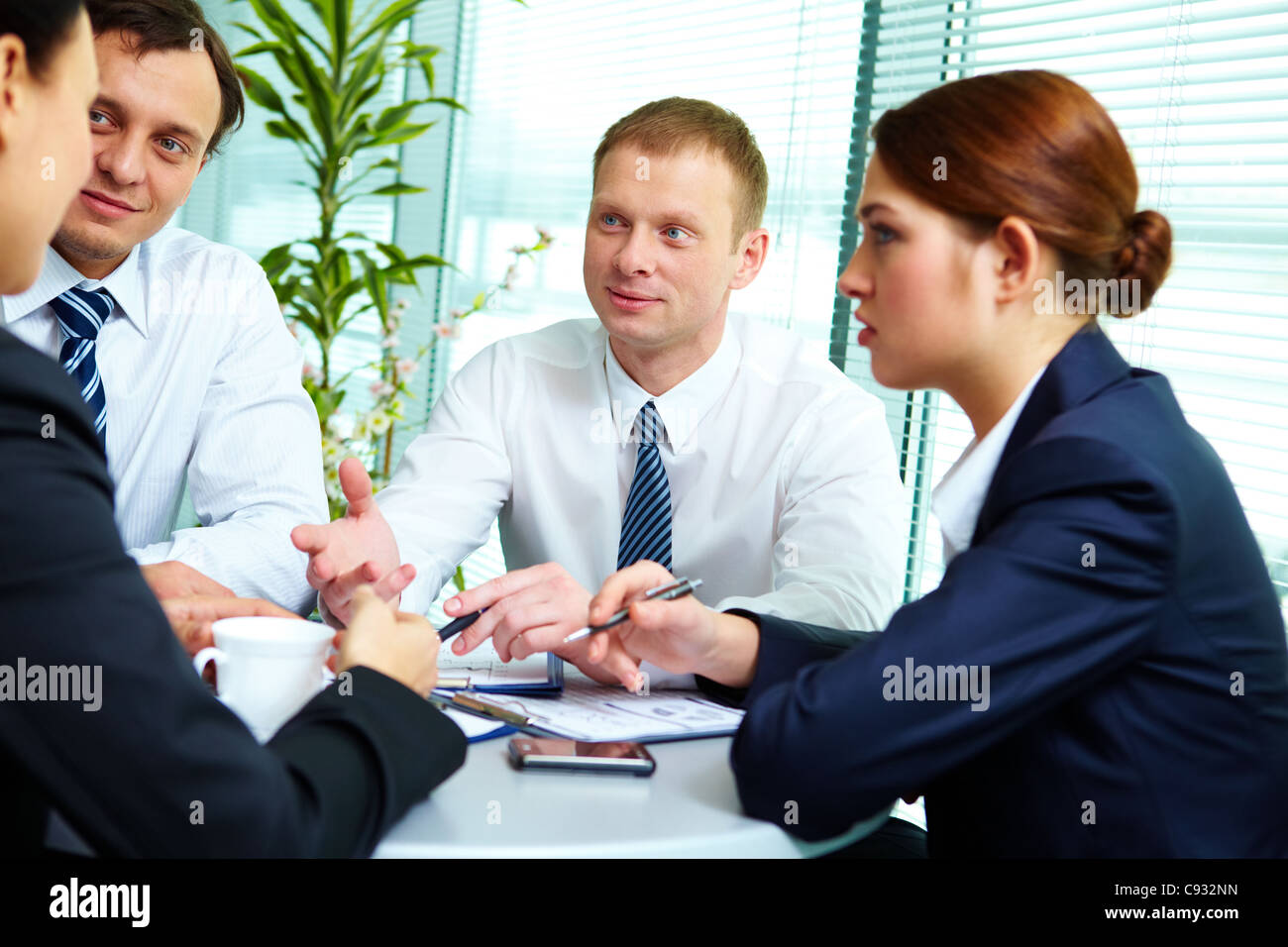 Image of confident colleagues communicating in office Stock Photo - Alamy