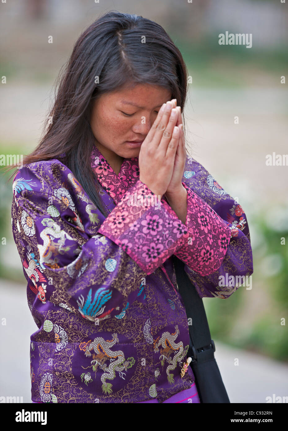 A woman deep in prayer at the Memorial Chorten, which dominates the ...