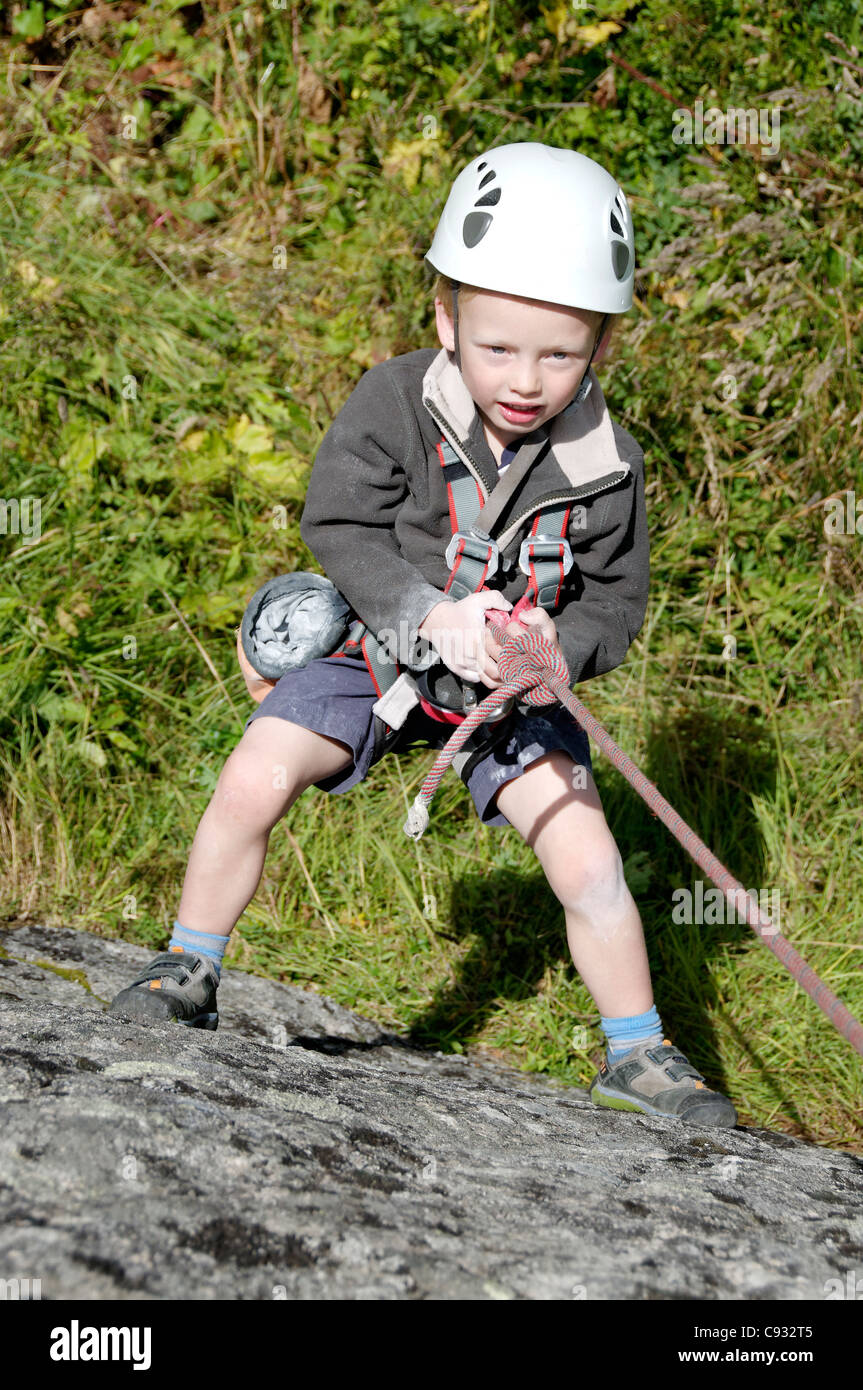 A young boy climbing on a small boulder Stock Photo - Alamy