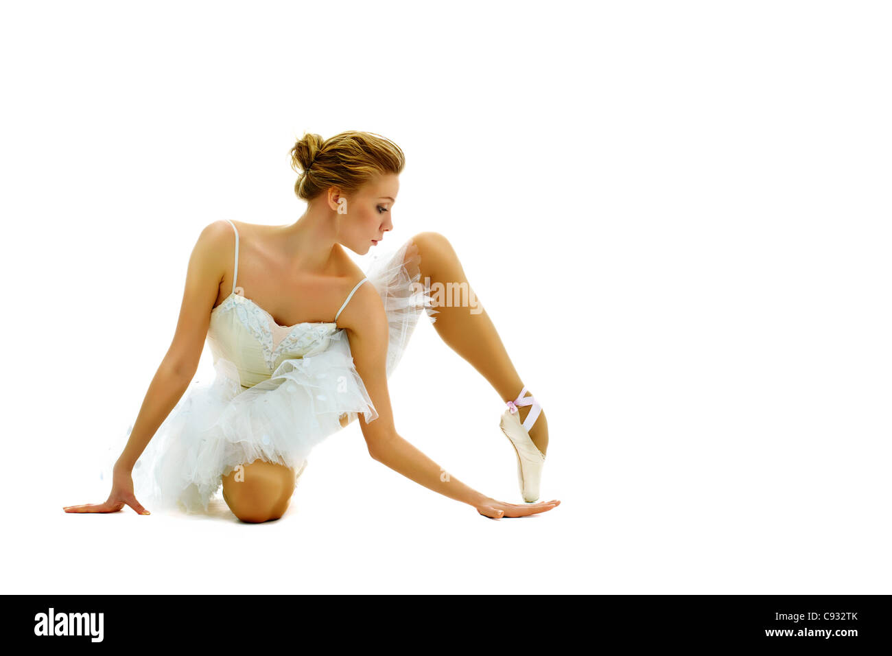 Portrait of graceful ballerina keeping balance on white background ...