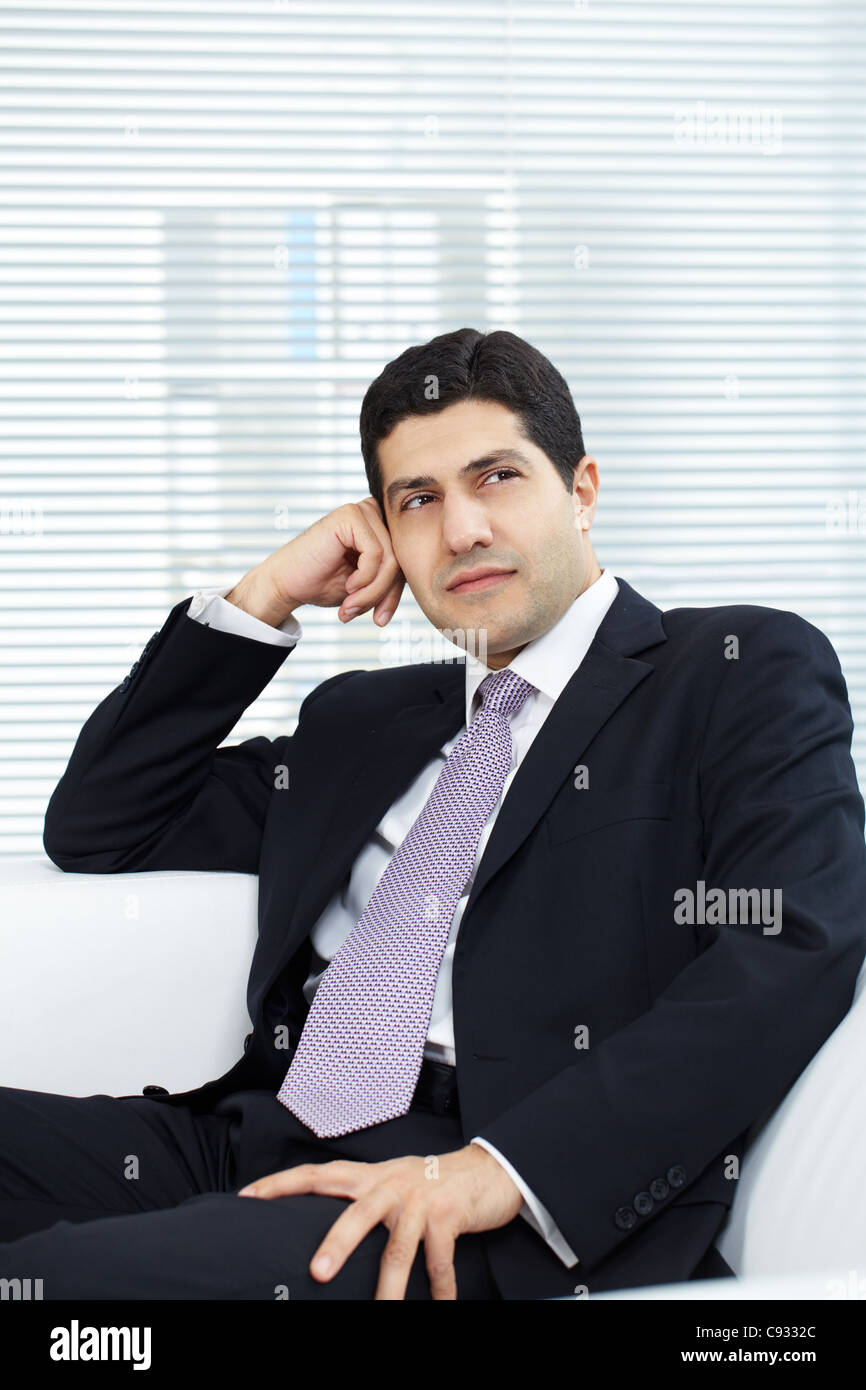 Portrait of attractive businessman in suit sitting in office Stock ...