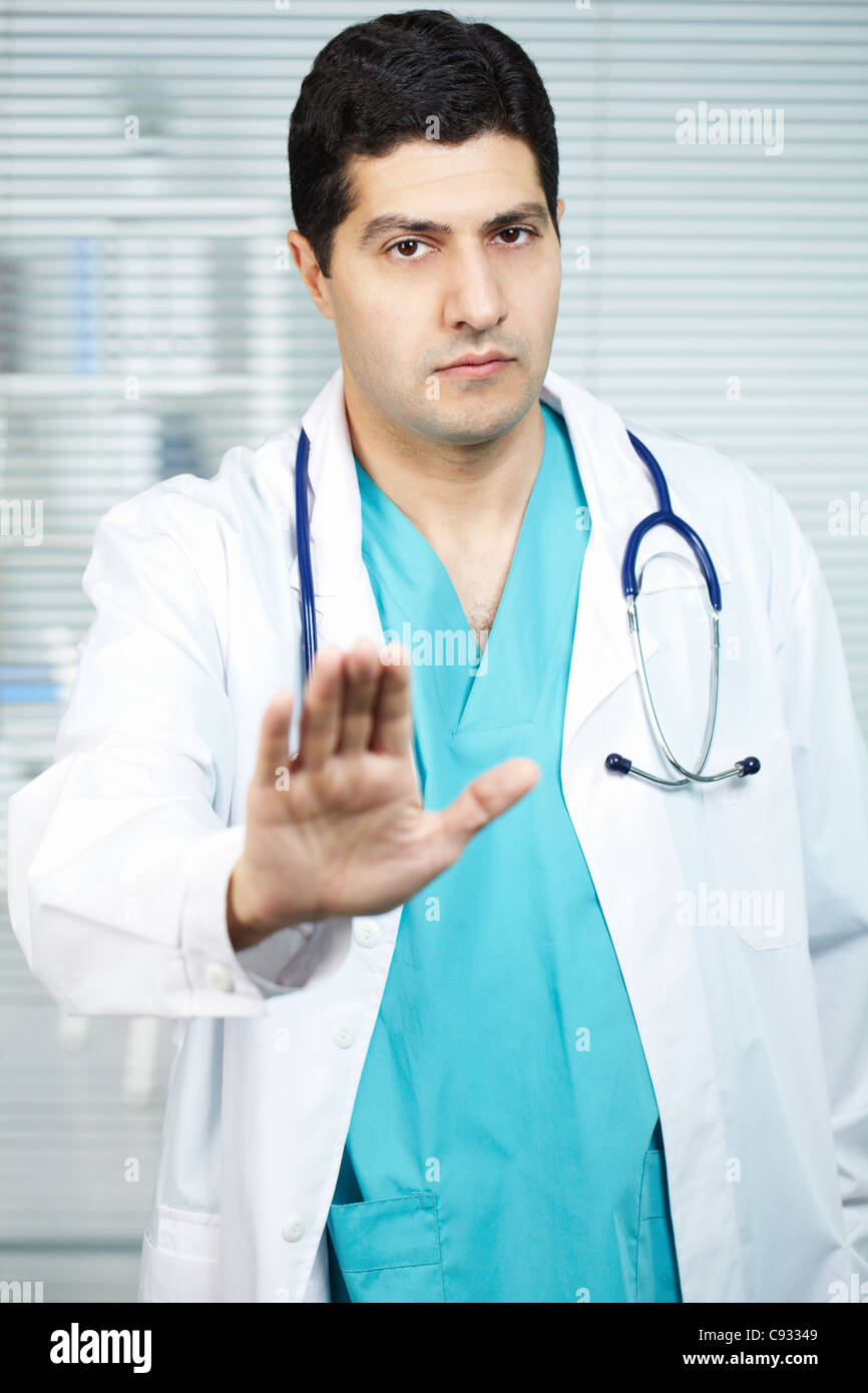 Portrait of serious doctor showing warning sign Stock Photo - Alamy