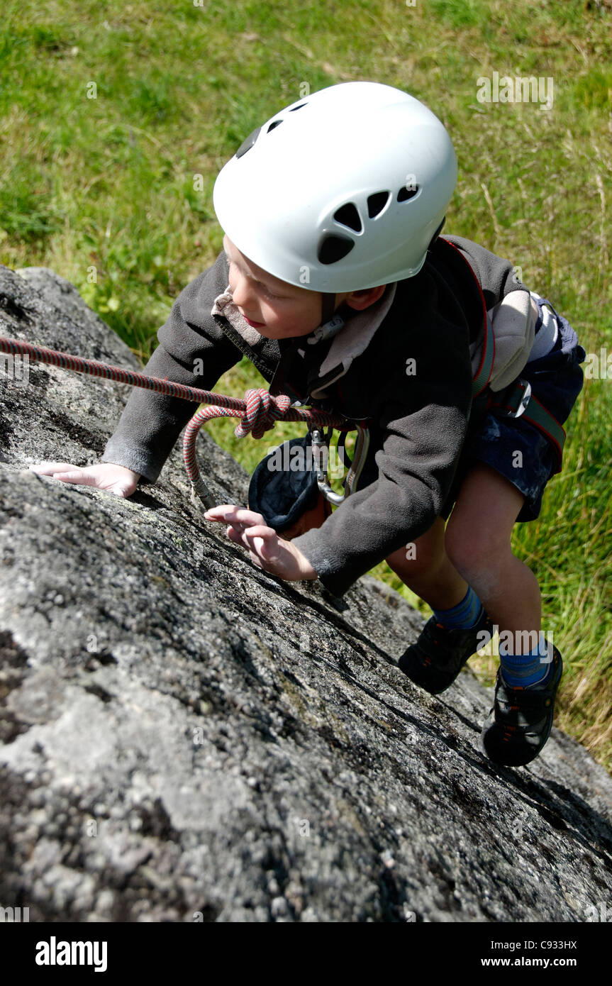 A young boy climbing on a small boulder Stock Photo - Alamy