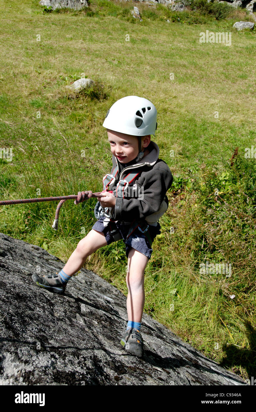 A young boy climbing on a small boulder Stock Photo - Alamy