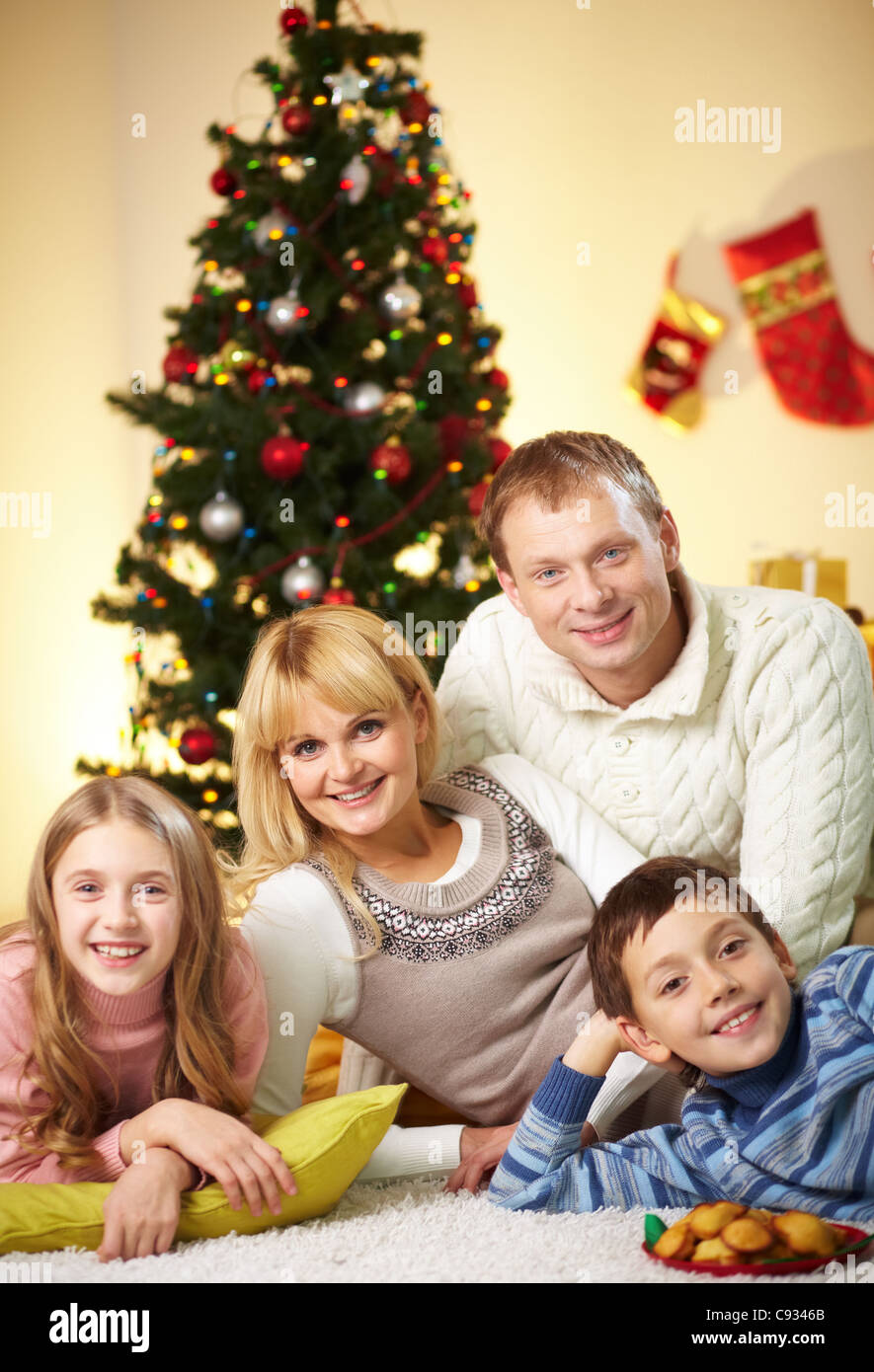 Portrait of four happy family members looking at camera with smiles ...
