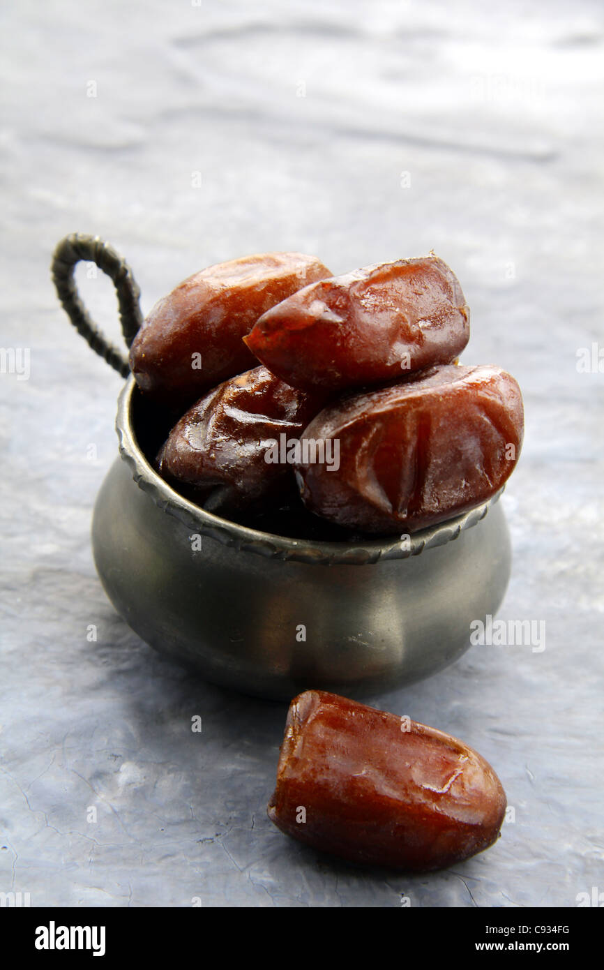dates in cup on grey background Stock Photo - Alamy