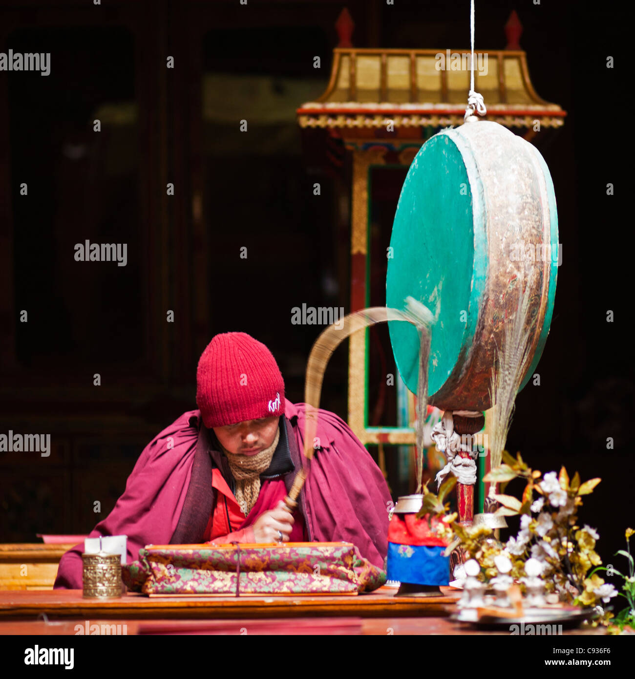 India, Ladakh, Hemis. Monk reciting prayers to the slow rhythm of a ...