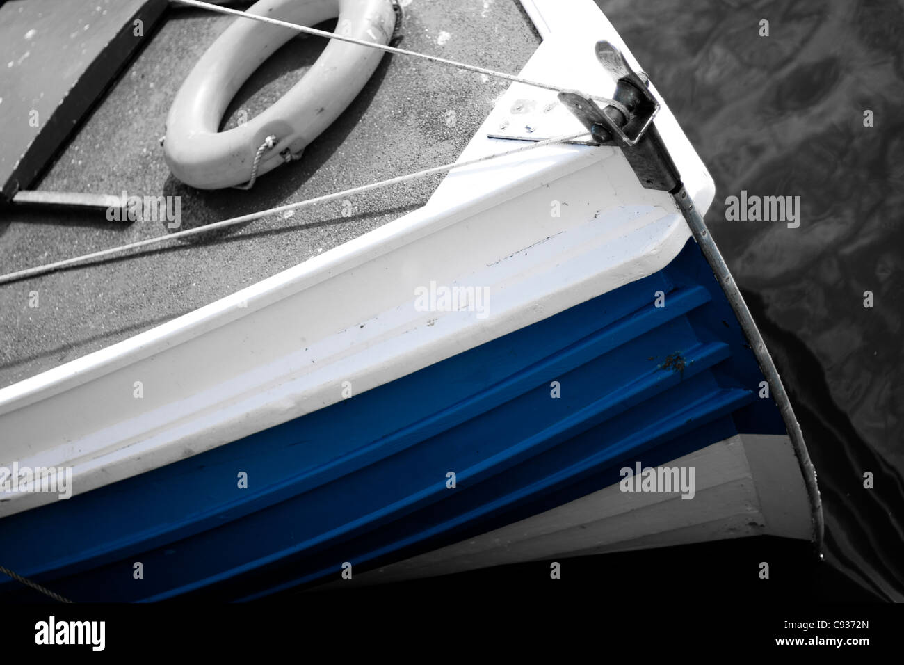 The front bow of a fishing boat on the water anchored up to a buoy ...