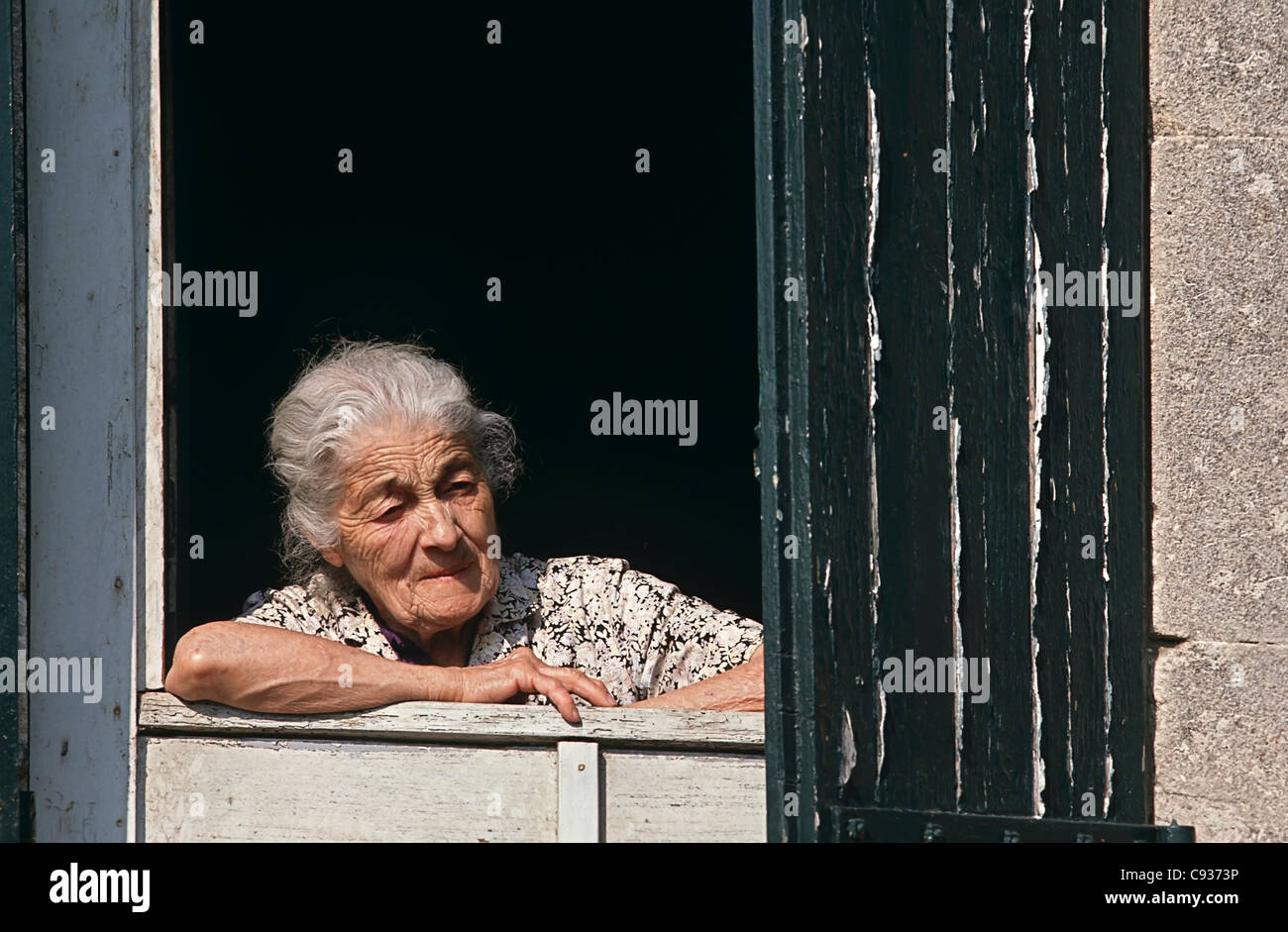Old lady looking out of her window Stock Photo - Alamy
