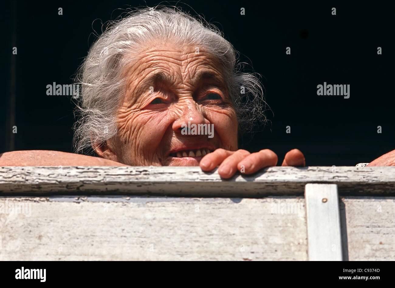 Old lady looking out of her window Stock Photo - Alamy