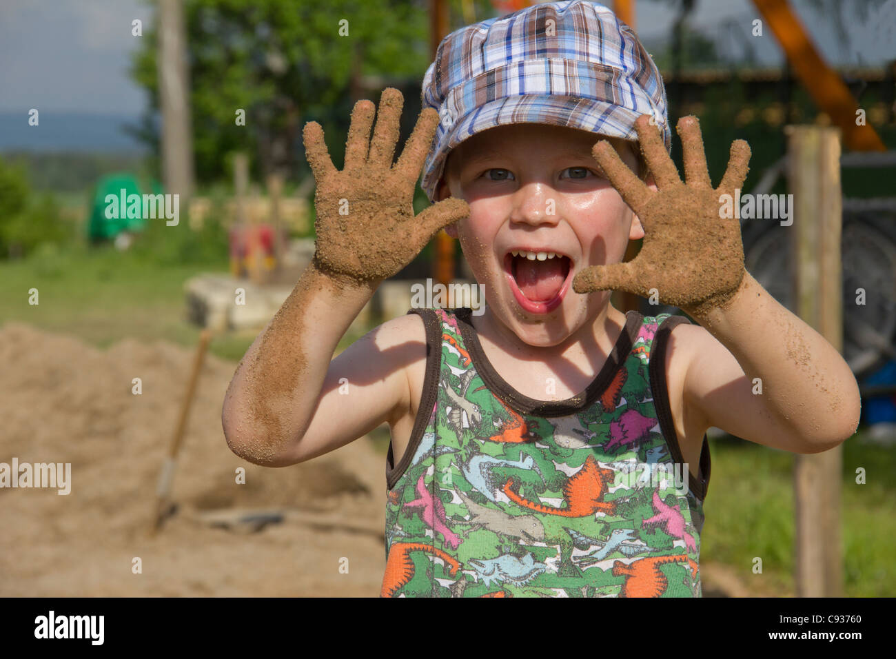 Boy playing in the garden with sandy hands Stock Photo - Alamy