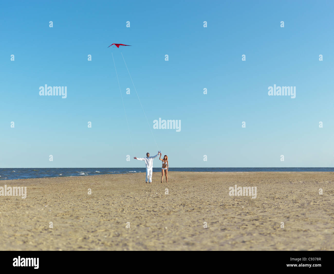 Happy young couple flying kite hi-res stock photography and images - Alamy