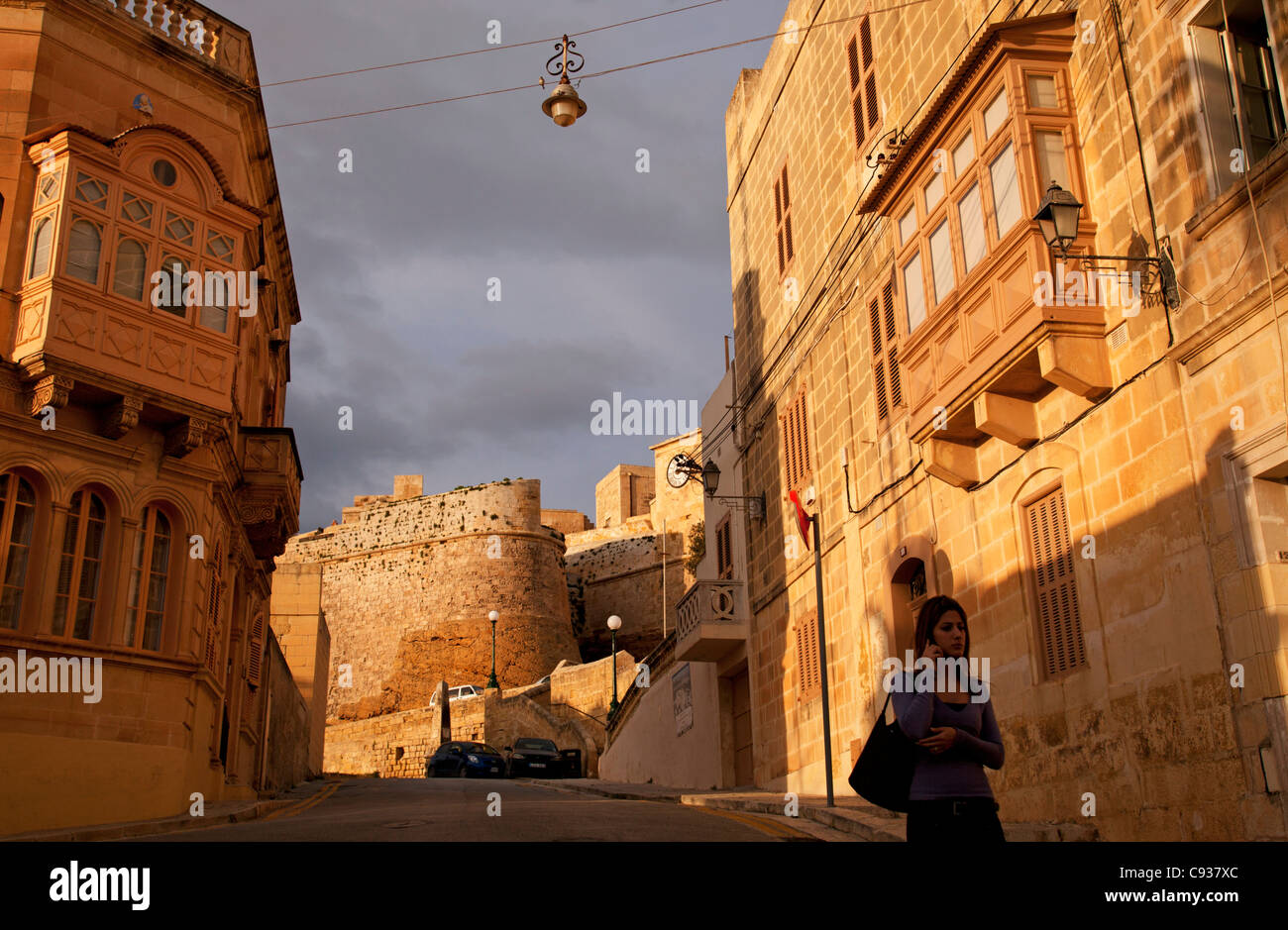 Gozo, Malta, Europe; A young woman walking in the streets of Victoria ...