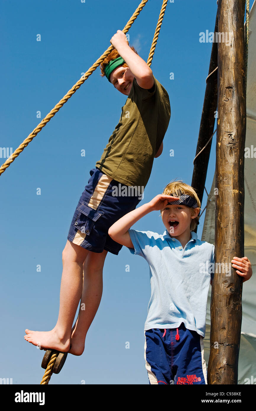 Malawi, Lake Malawi National Park. Boys climb the rigging of a dhow ...