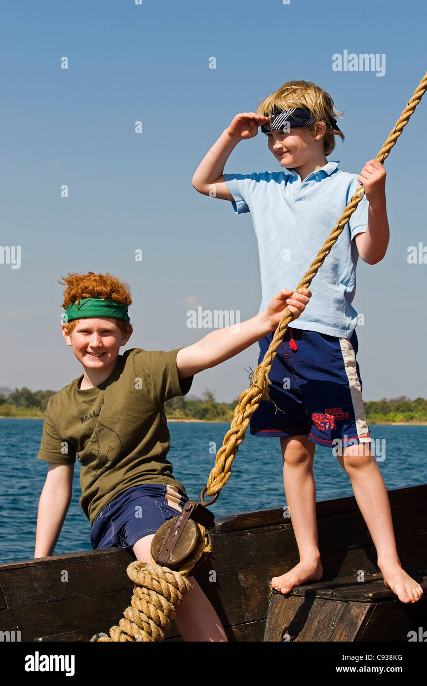 Malawi, Lake Malawi National Park. Boys climb the rigging of a dhow ...