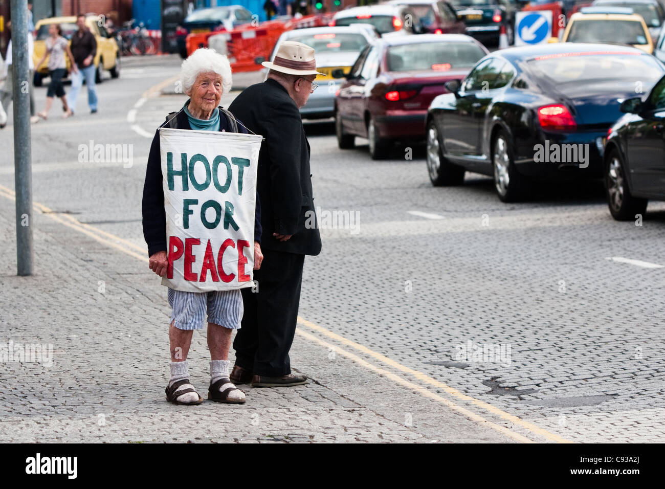 Elderly peace activist with 'Hoot for peace banner', Bristol, England ...