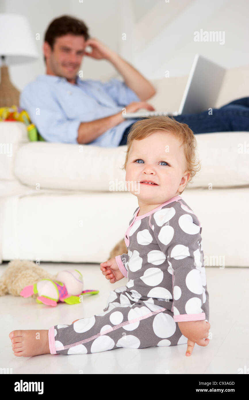 Busy father working on laptop Stock Photo - Alamy