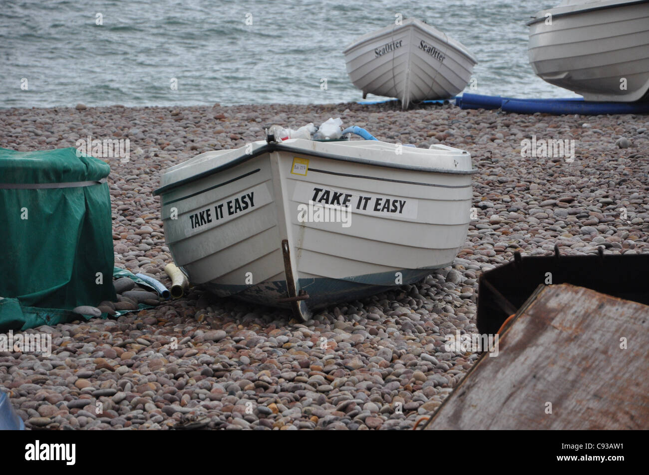 Small boats resting on pebble foreshore Stock Photo - Alamy