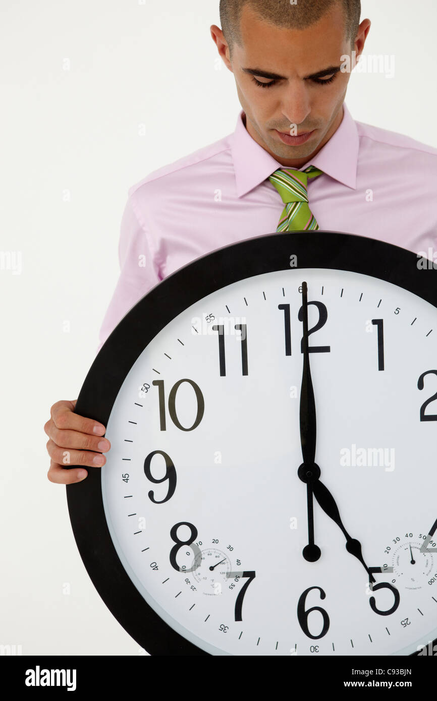 Young businessman with giant clock Stock Photo - Alamy
