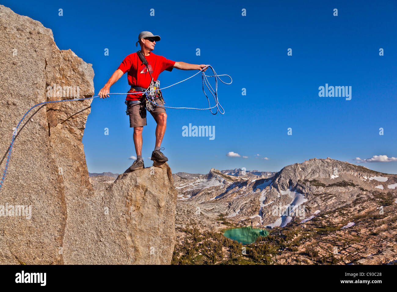 Male rock climber celebrates on the summit after a successful ascent ...