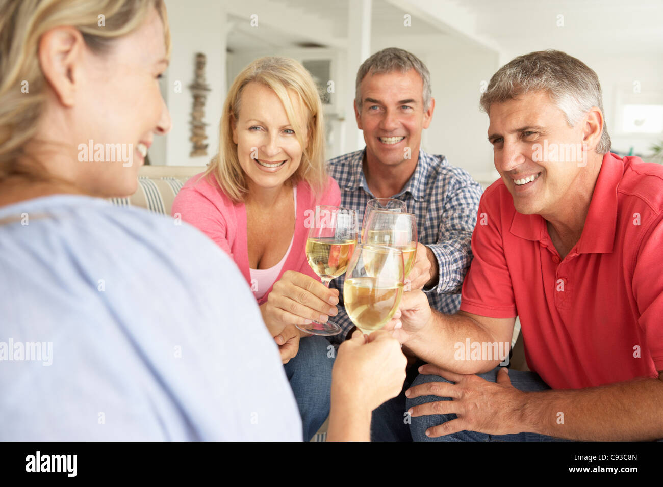 Mid age couples drinking together at home Stock Photo - Alamy