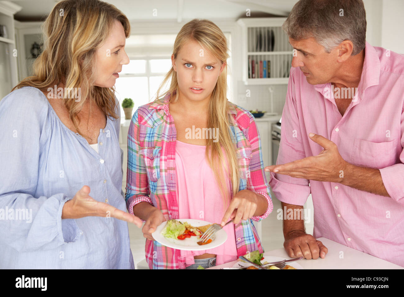 Parents making teenage daughter do chores at home Stock Photo - Alamy