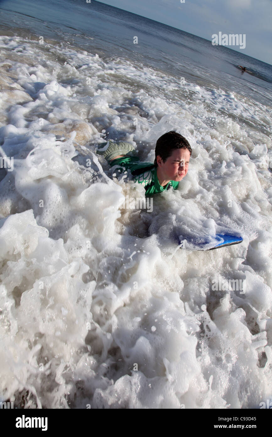 Boy bodyboarding in the surf at Fair Harbor Beach, Fire Island, NY, USA ...