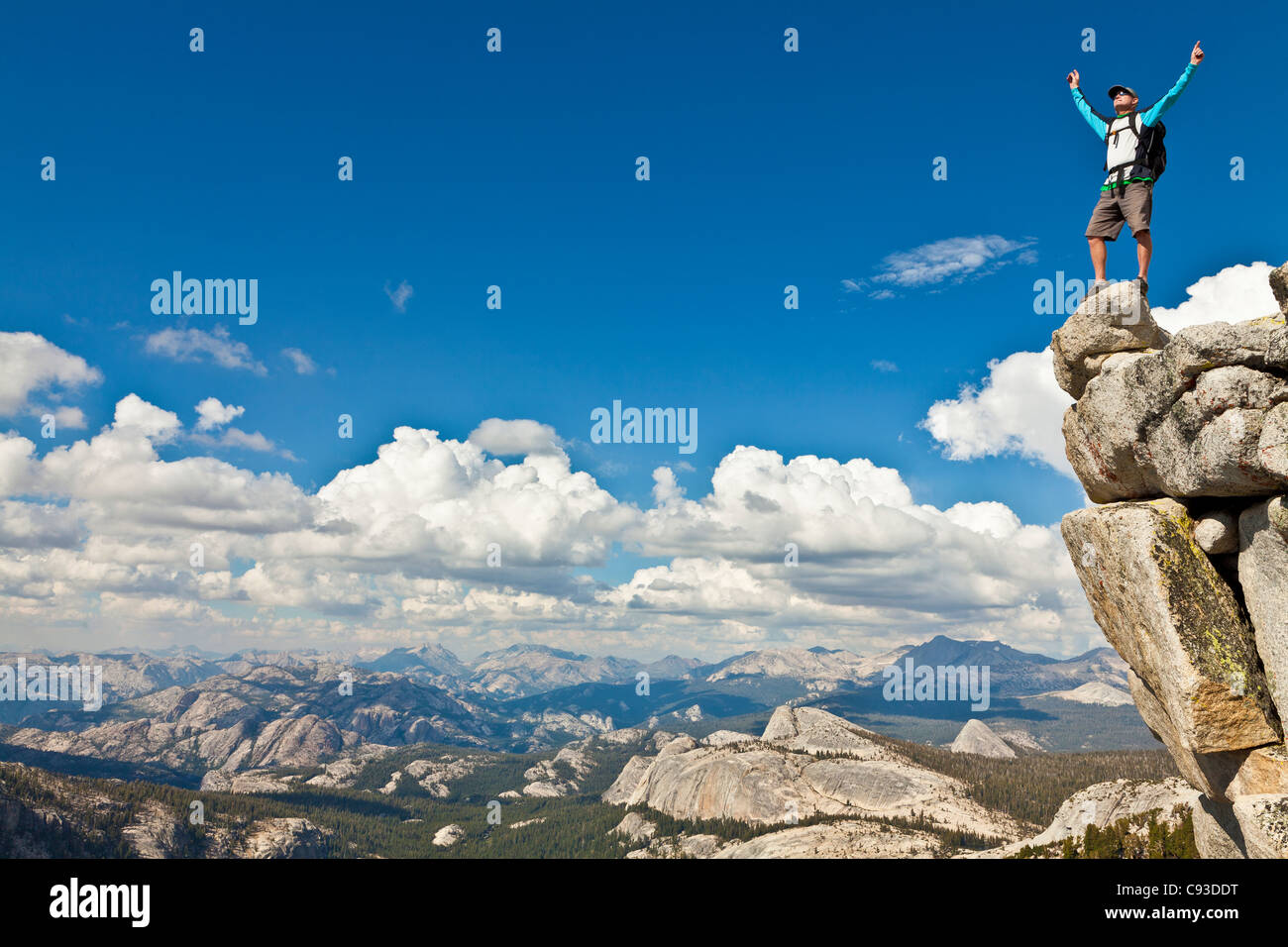 Male rock climber celebrates on the summit after a successful ascent ...