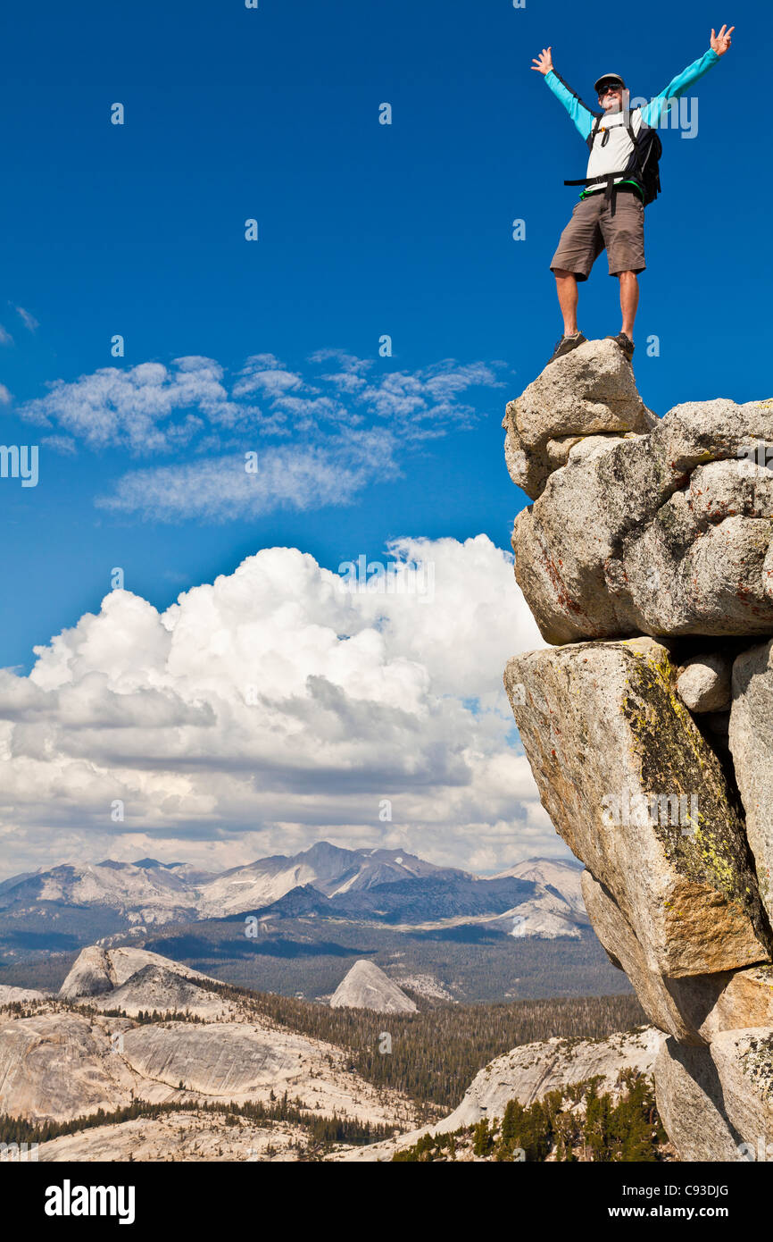 Male rock climber celebrates on the summit after a successful ascent ...