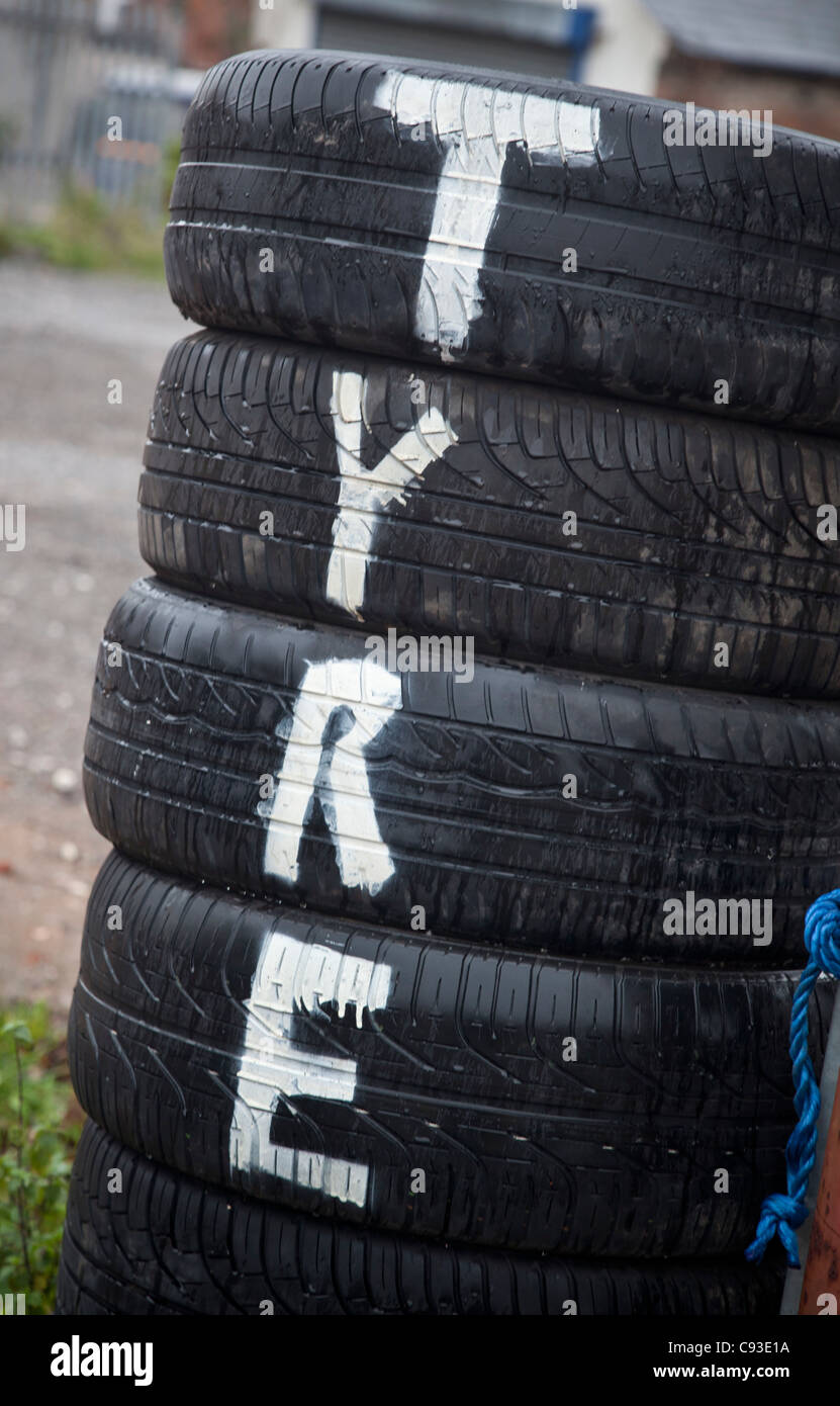 A sign stating the obvious on a pile of used tyres Stock Photo - Alamy