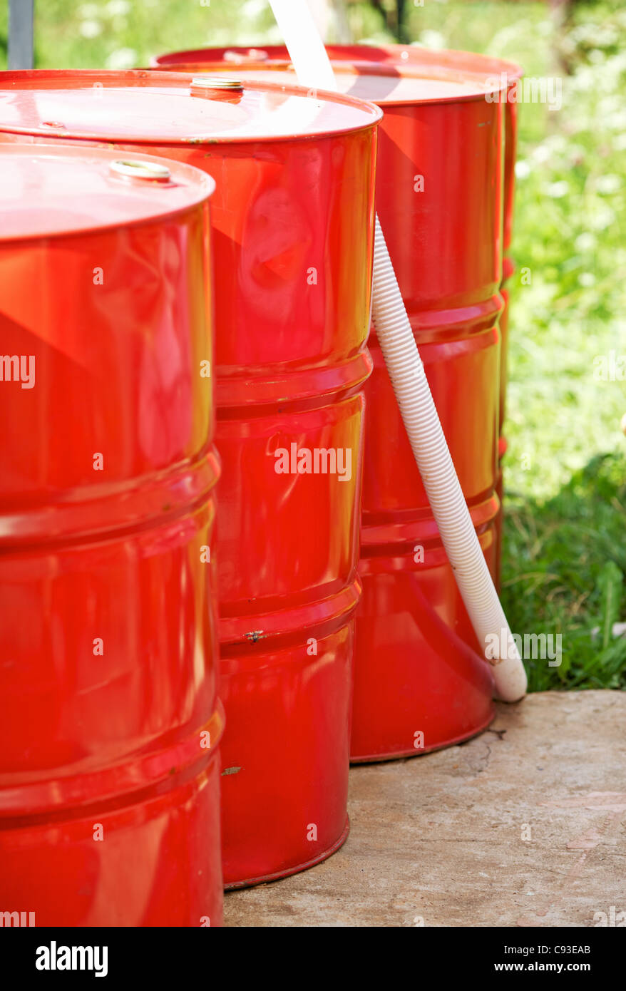 three old red metal barrels in yard Stock Photo - Alamy