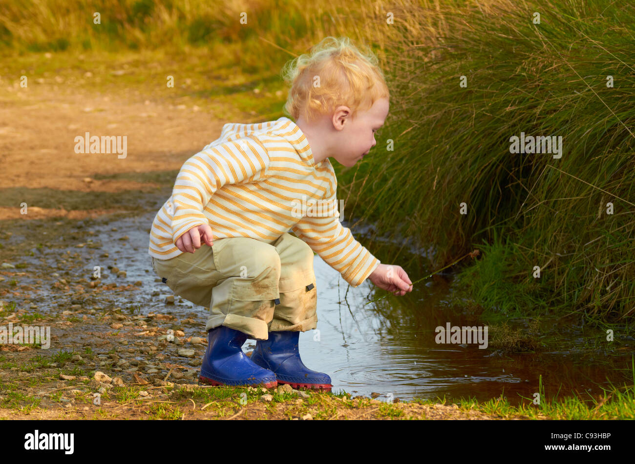 Boy playing in puddle and water Stock Photo - Alamy